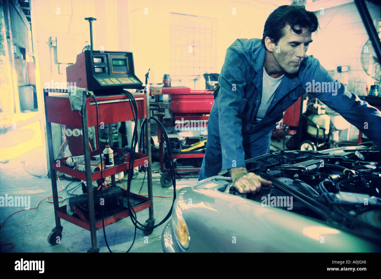 Auto mechanic working over the engine bay of a car Stock Photo - Alamy