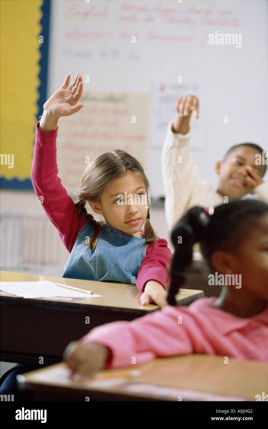 School children raising their hands in class Stock Photo - Alamy