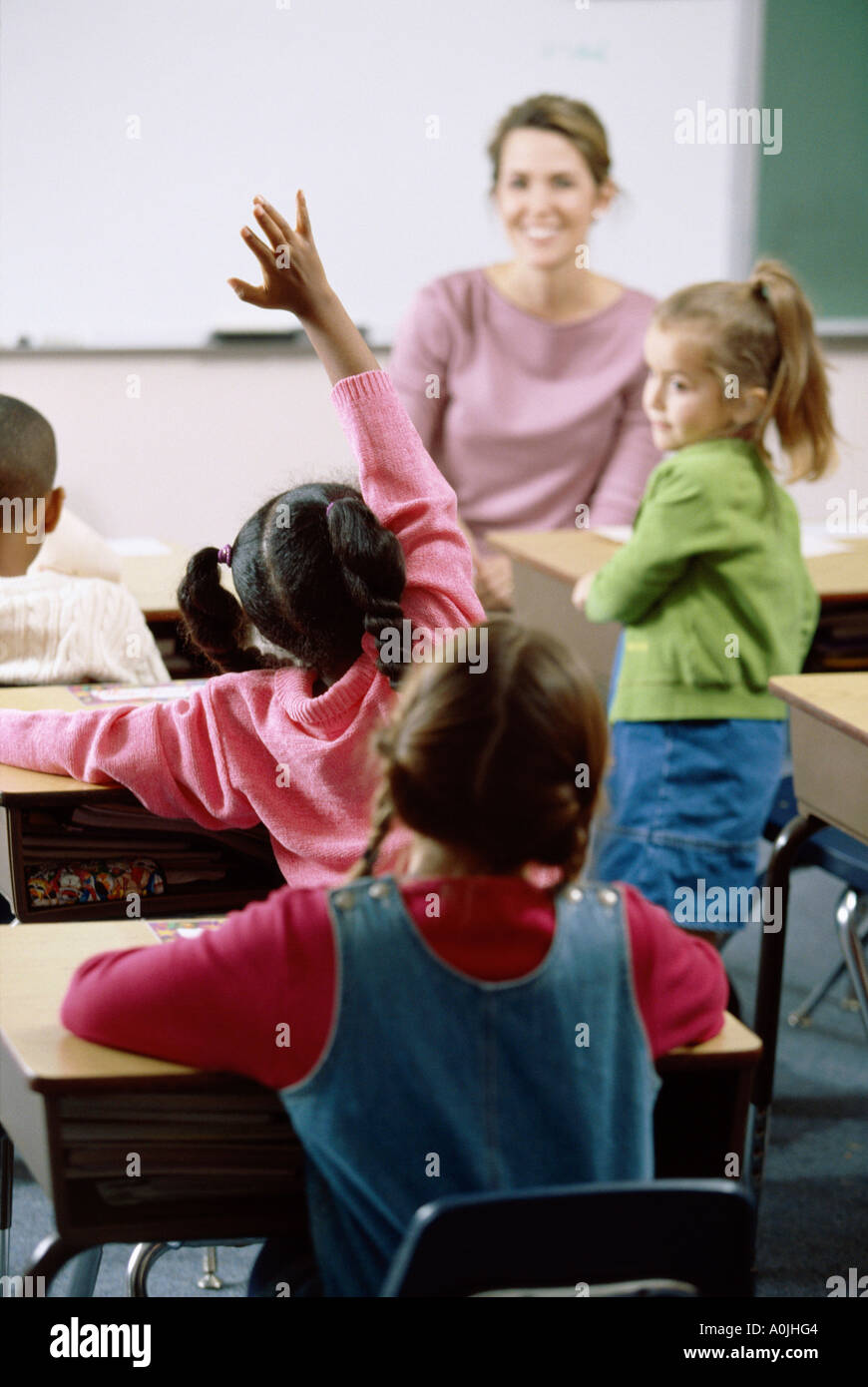 School children raising their hands in class Stock Photo - Alamy