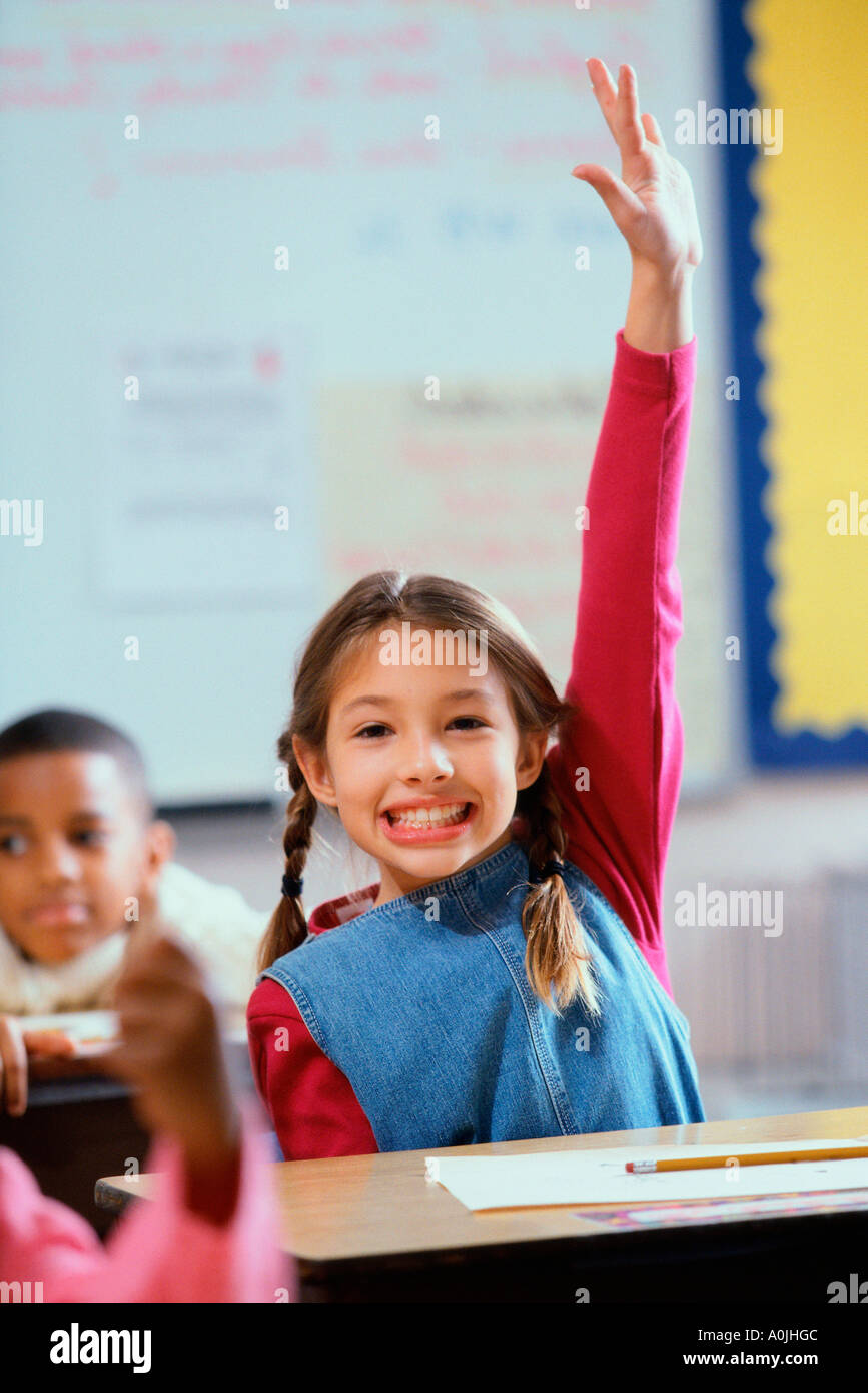 Portrait of a girl raising her hand in class Stock Photo - Alamy