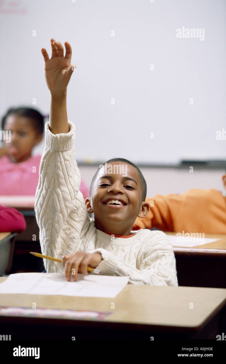 Portrait of a boy raising his hand in class Stock Photo - Alamy