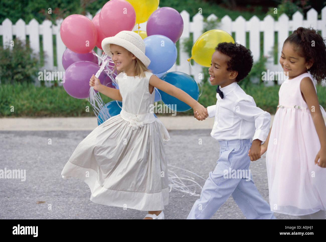 Side profile of two girls and a boy walking together holding hands ...