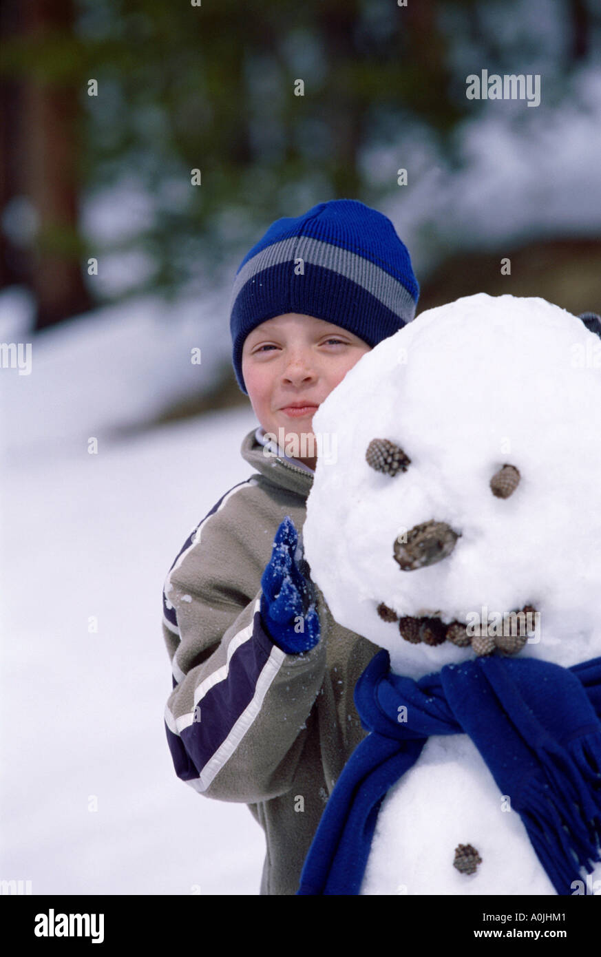 Boy standing behind snowman hi-res stock photography and images - Alamy