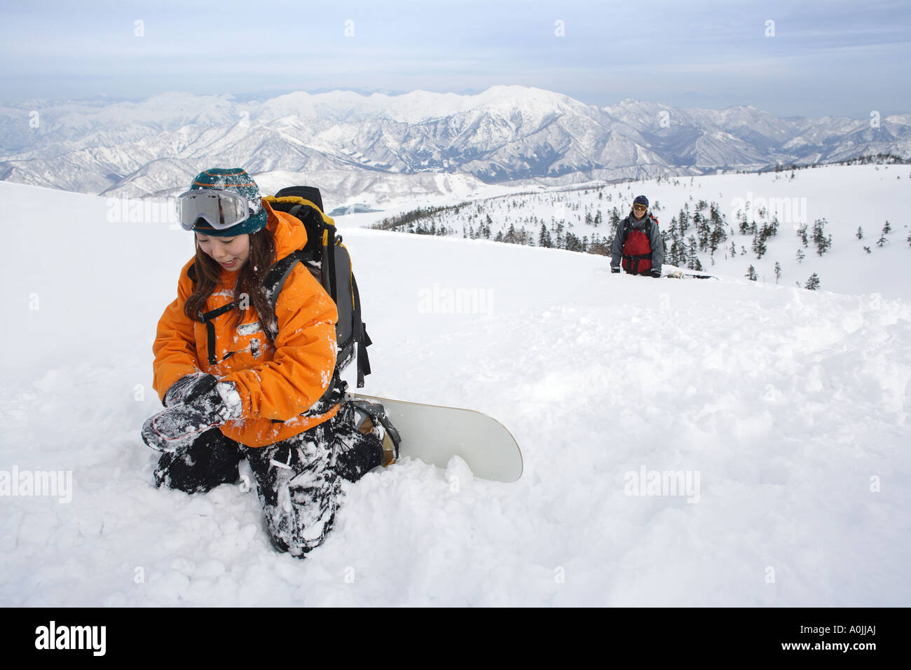 Asian female snowboarder with friend Stock Photo - Alamy