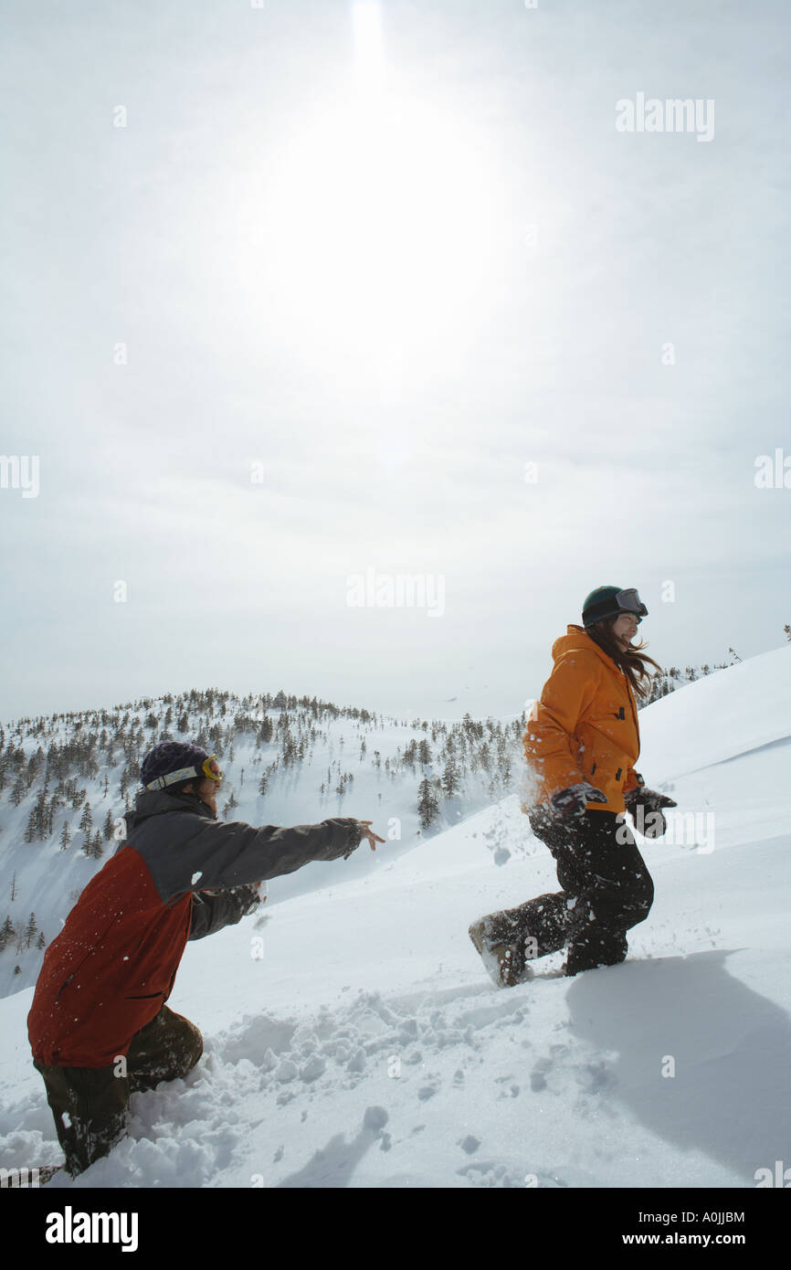 Two snowboarders trudging through snow Stock Photo - Alamy