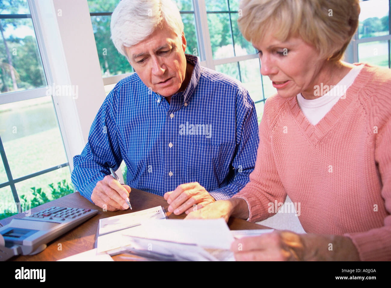 Senior couple sitting together calculating bills Stock Photo - Alamy