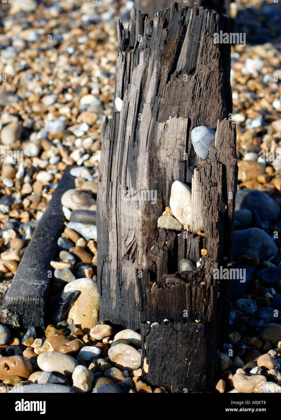 Wooden bollard and beach pebbles Stock Photo - Alamy