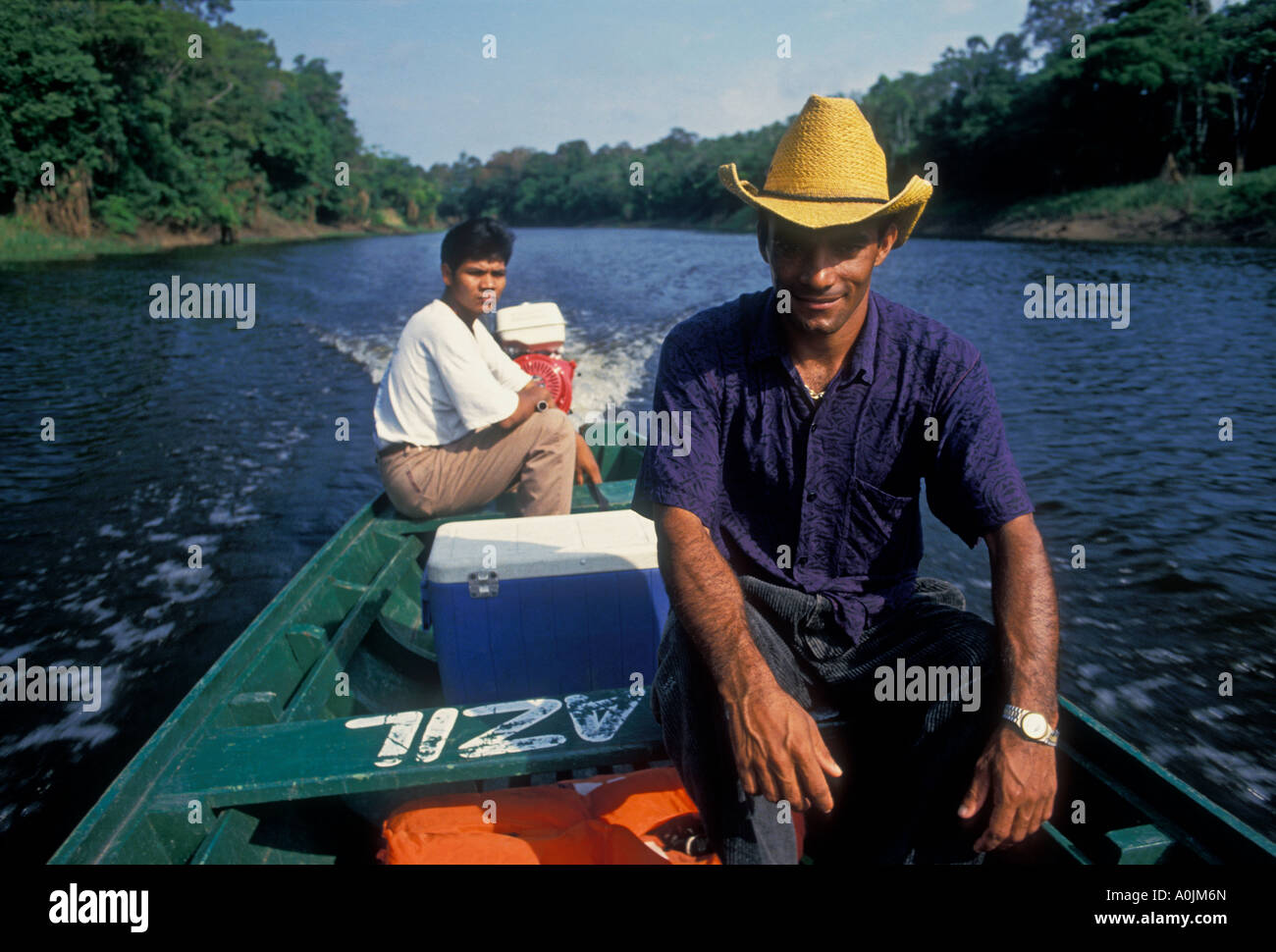 2 two Brazilian men riding in motorboat along the Ariau River, Rio ...