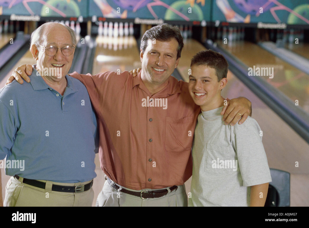 Man standing with his father and son in a bowling alley Stock Photo - Alamy
