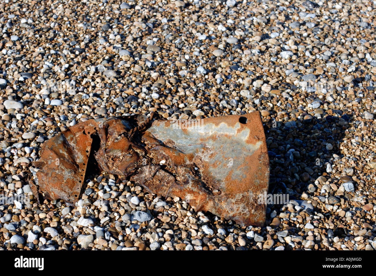 Rusty metal debris on pebble beach Stock Photo - Alamy