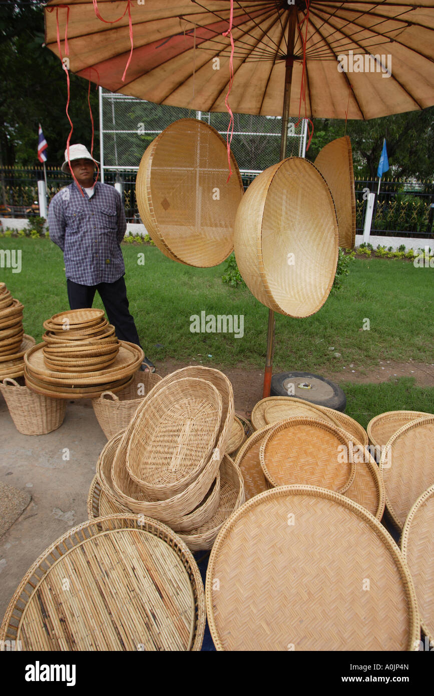 A Basket seller standing beside his wares that are laid out on the ...