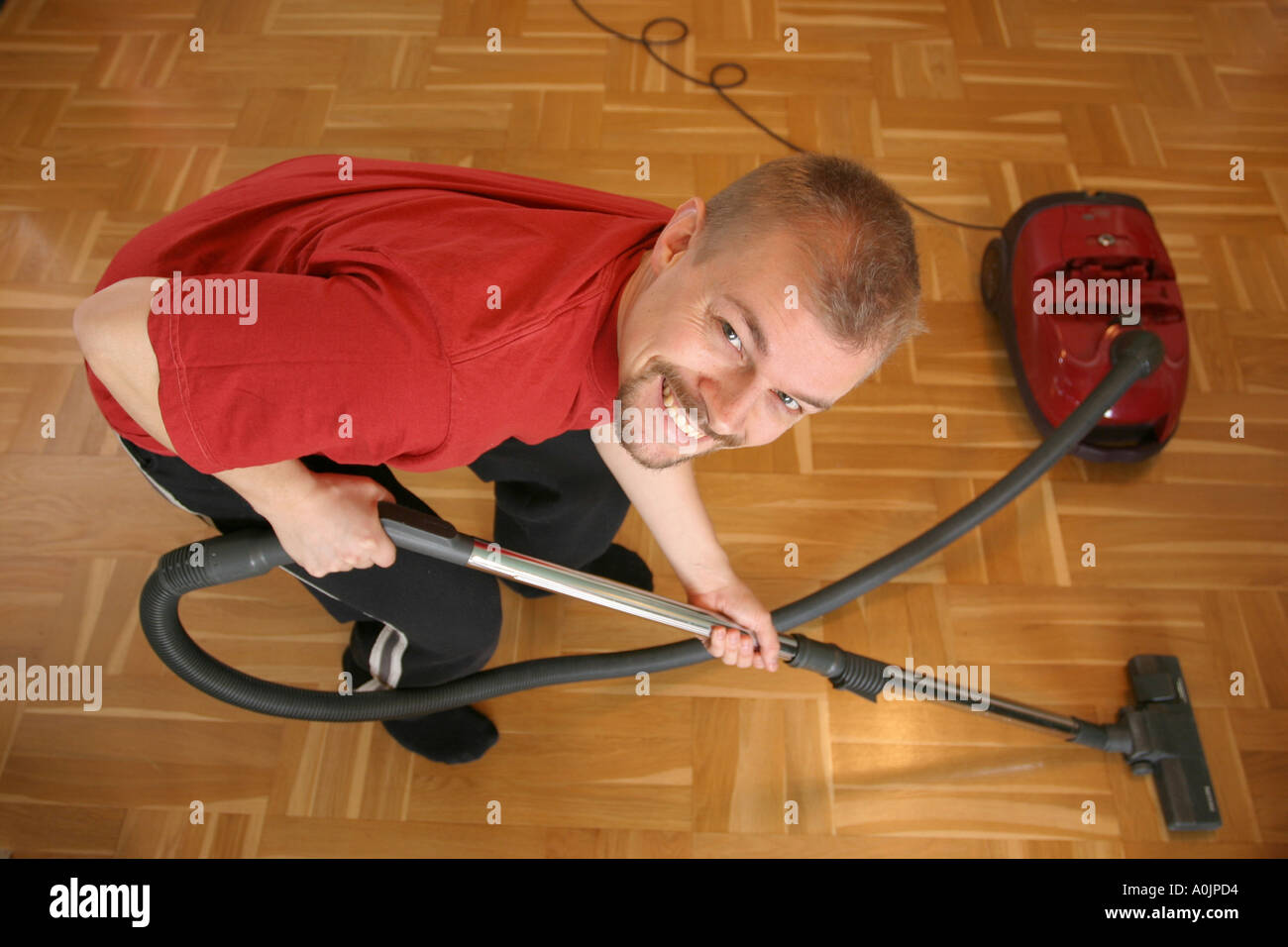 Happy man vacuum cleaning the floor Stock Photo - Alamy