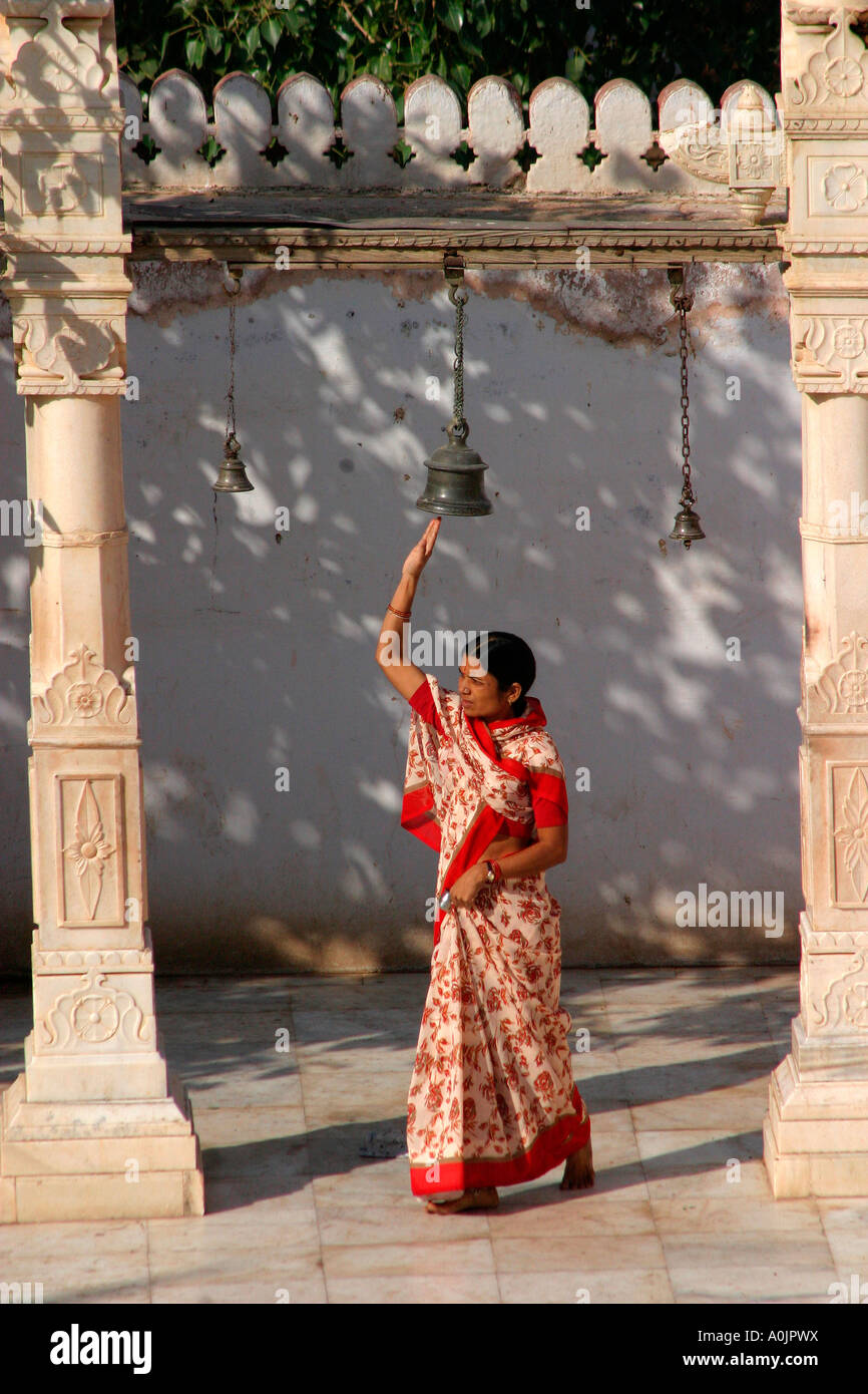 Rajasthani woman ringing a bell at the Sandeshwar Temple in Bikaner ...