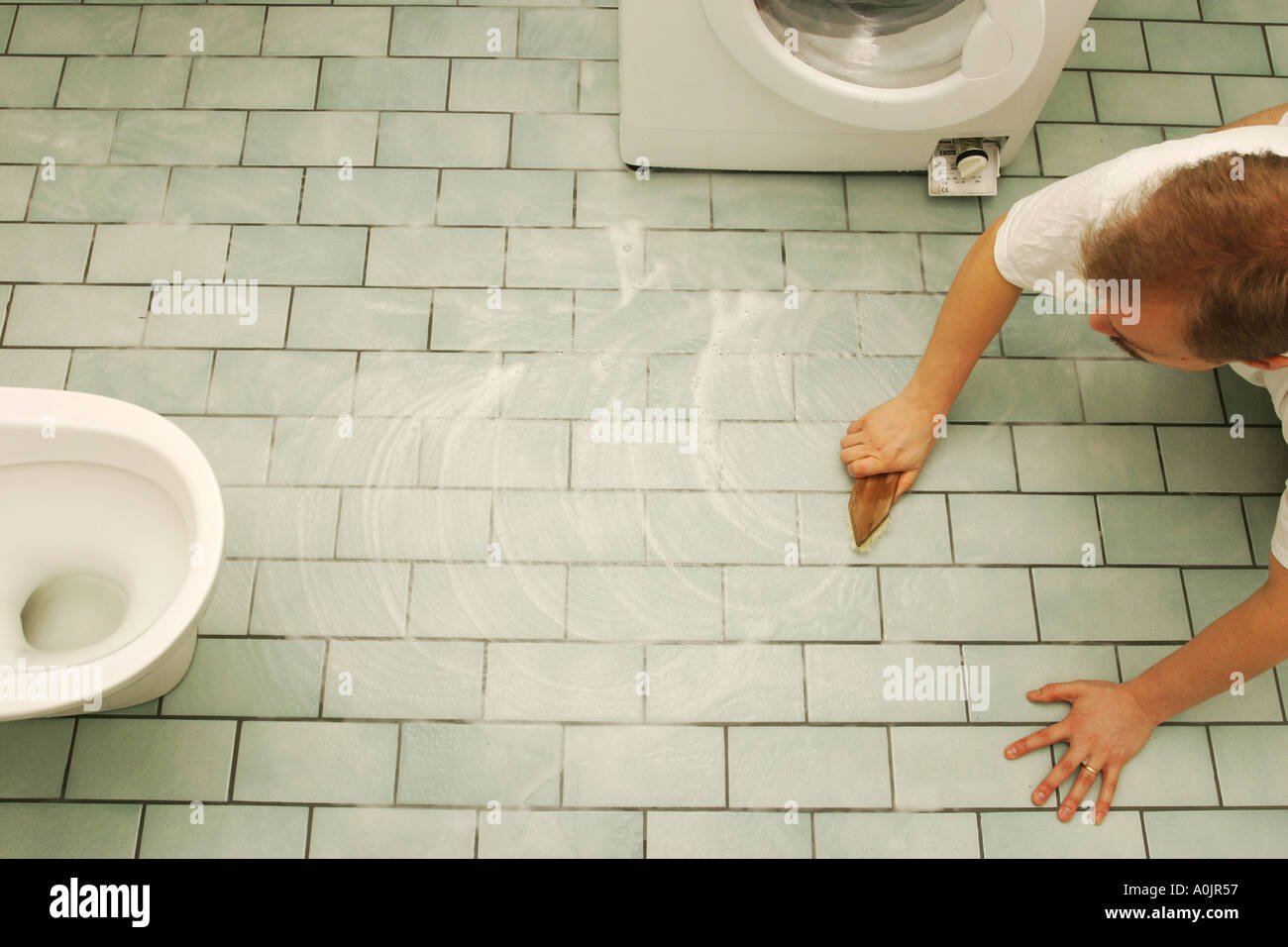 Man scrubbing a bathroom floor Stock Photo - Alamy