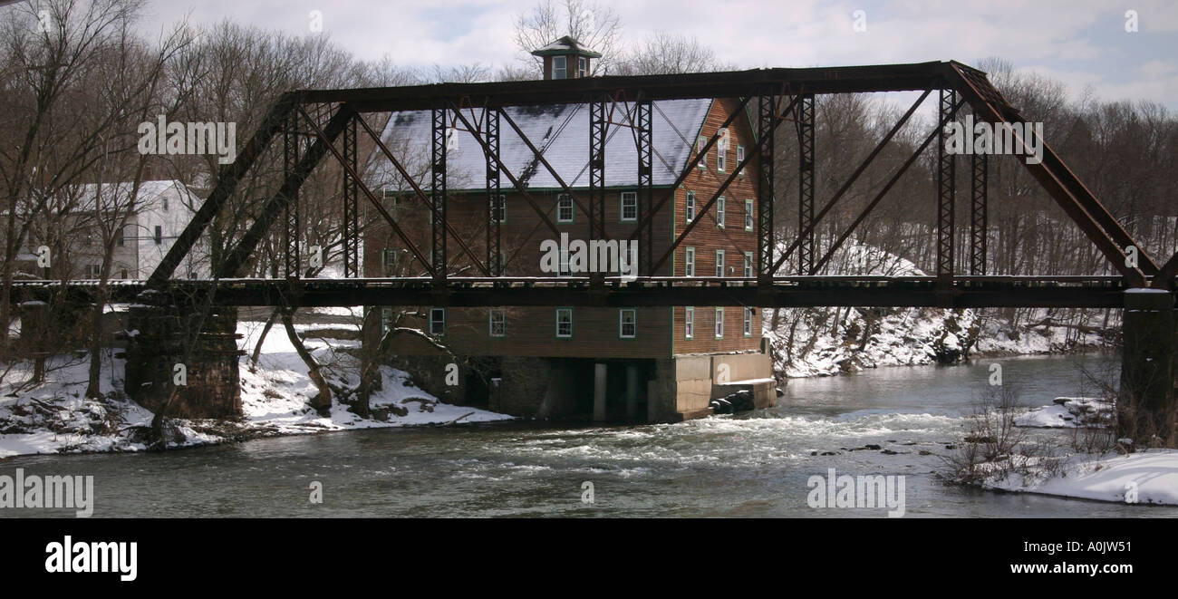 An old steel railroad bridge witha restored mill in the backgroung ...
