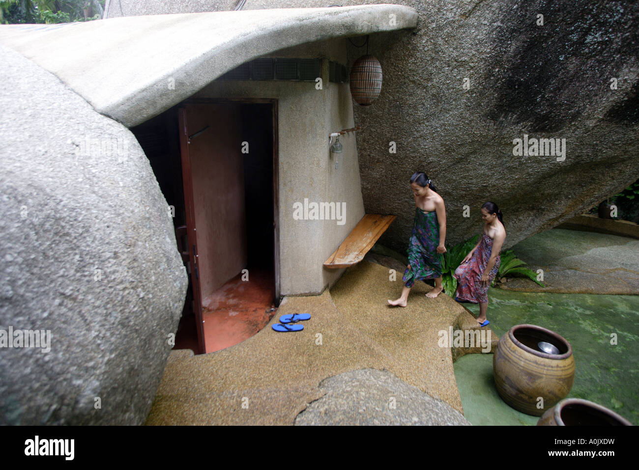 Two ladies in sarongs enter a treatment room built into the rocks at ...