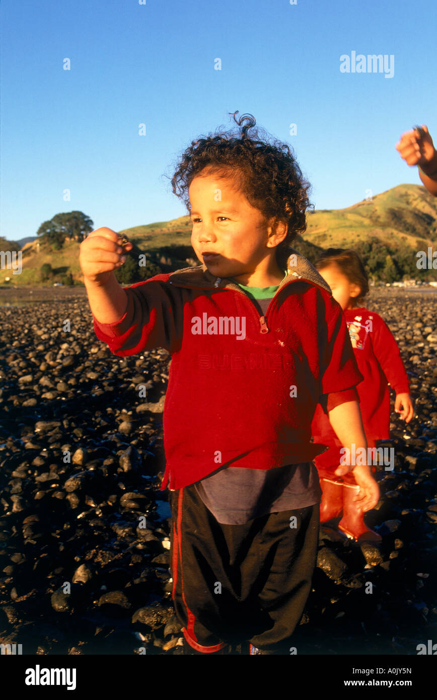 Two young children mussel gathering on the west coast of the Coromandel ...