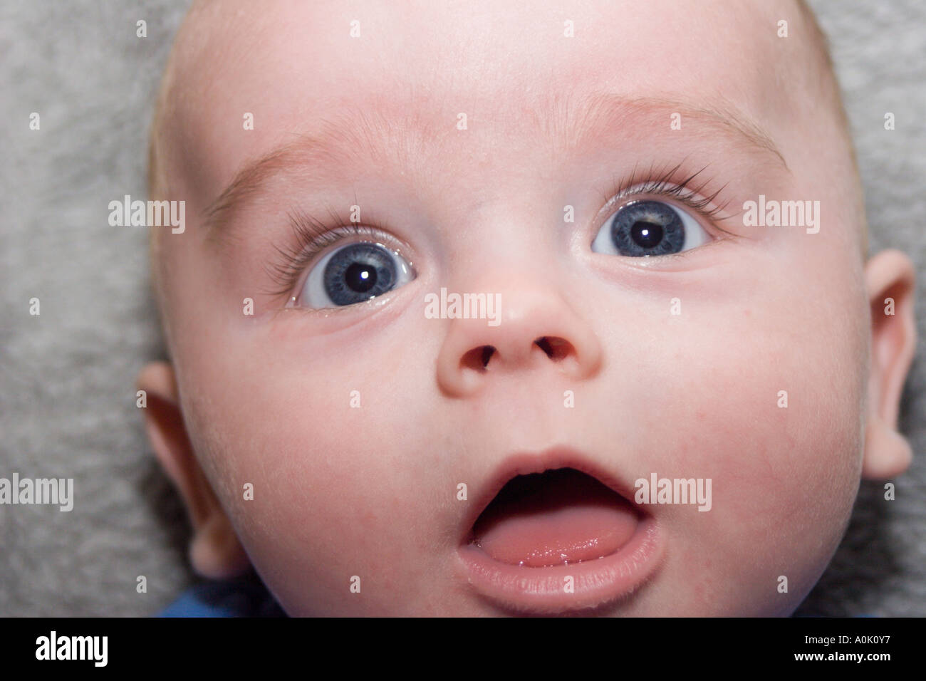 colour image off a close up shot off a young baby boys face. looking ...