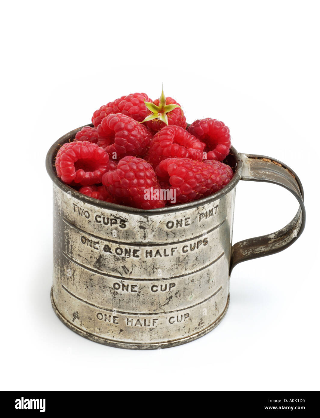 Tin measuring cup of full of fresh red raspberries Stock Photo - Alamy