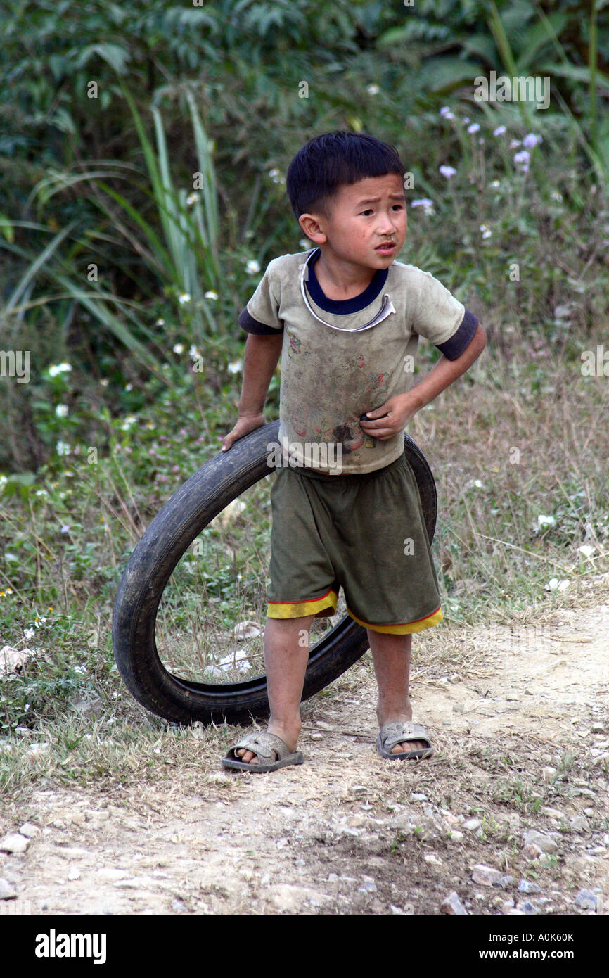 A boy carrying a worn moped tyre in a village in the Hoa Binh province ...