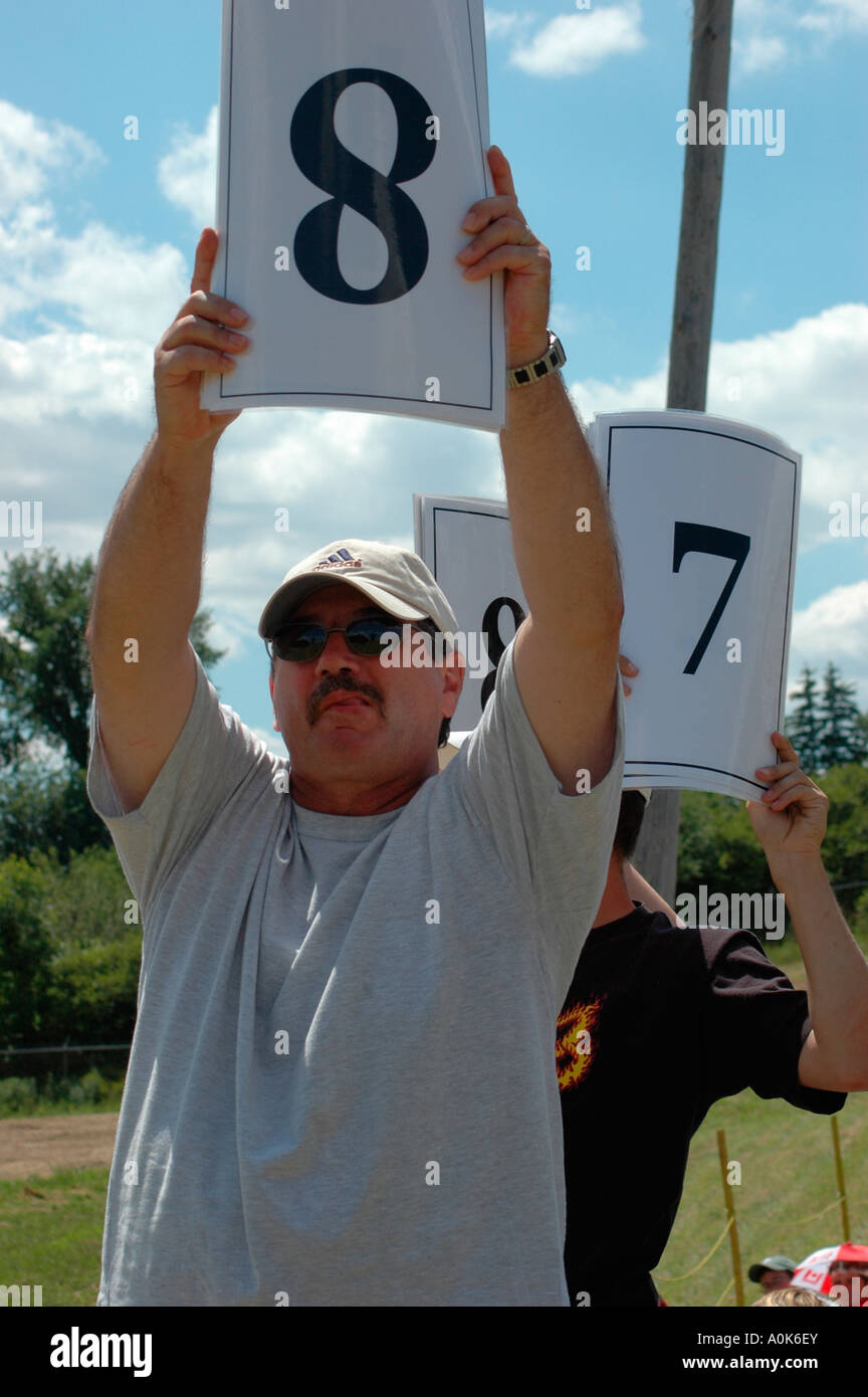 Judges hold score cards for motorcycle extreme stunt performers, 8 ...
