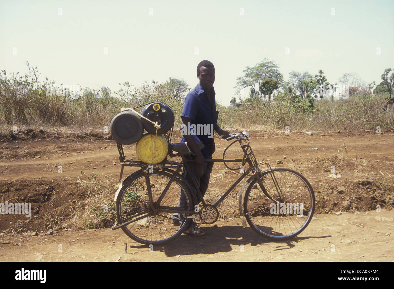 Young Meru man with a heavy load of water on his bicycle Near Meru ...
