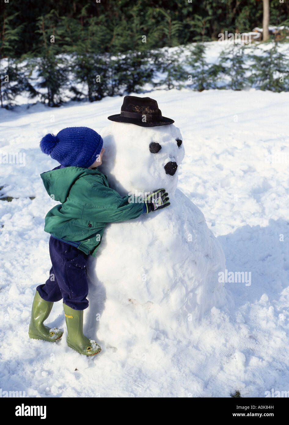 Child Hugging Snowman Stock Photo - Alamy