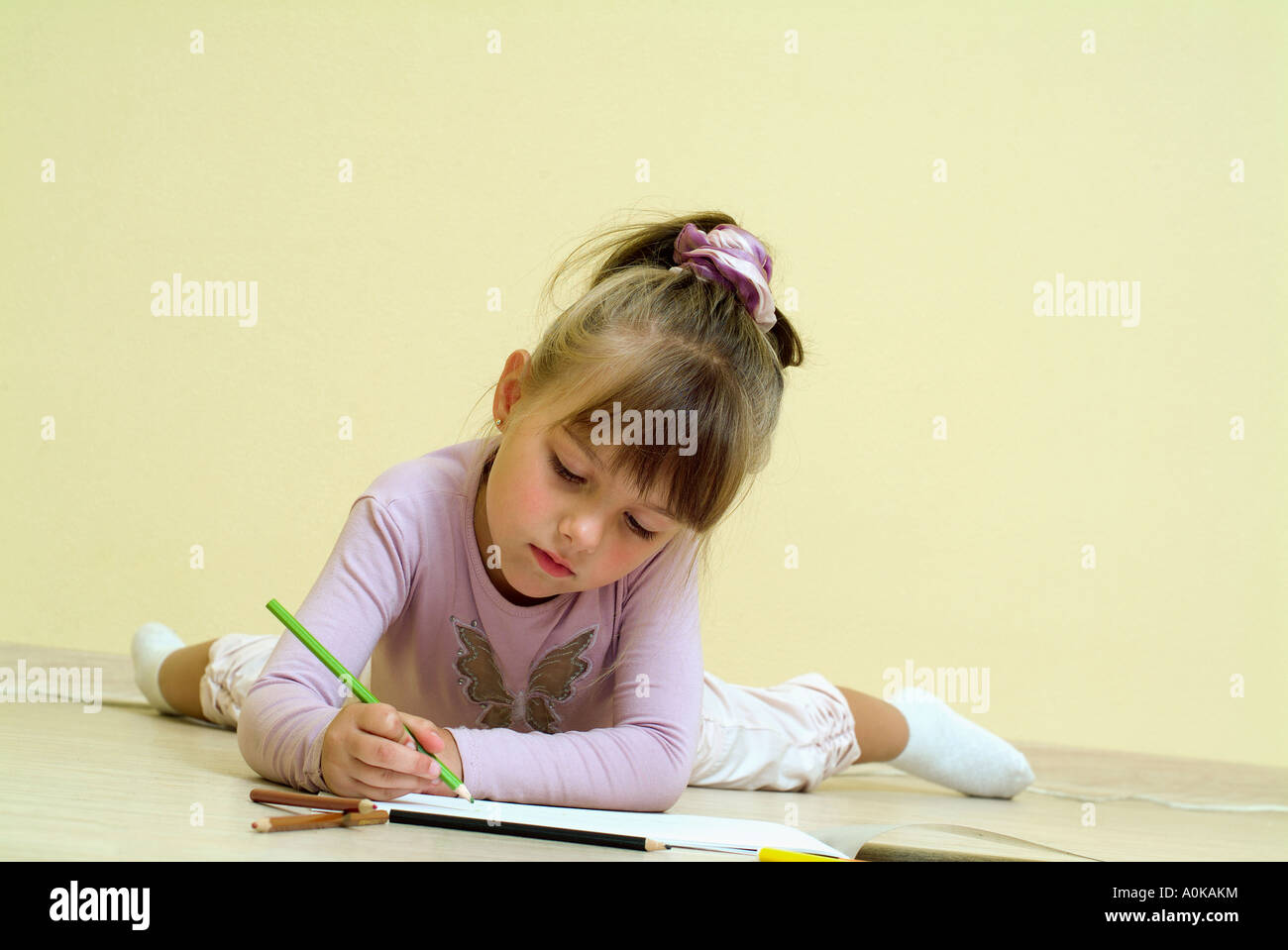 young girl lying on floor drawing Stock Photo - Alamy