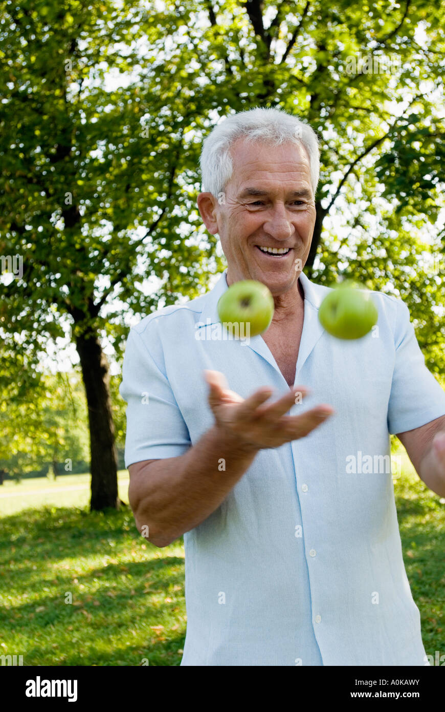 smiling mature man juggling with fruit Stock Photo - Alamy
