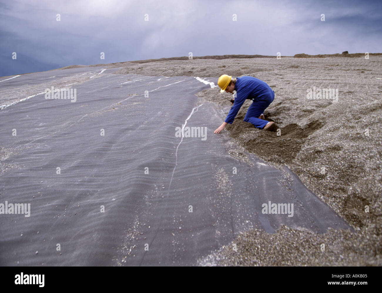 Maintenance worker installing membrane enabling collection of methane ...
