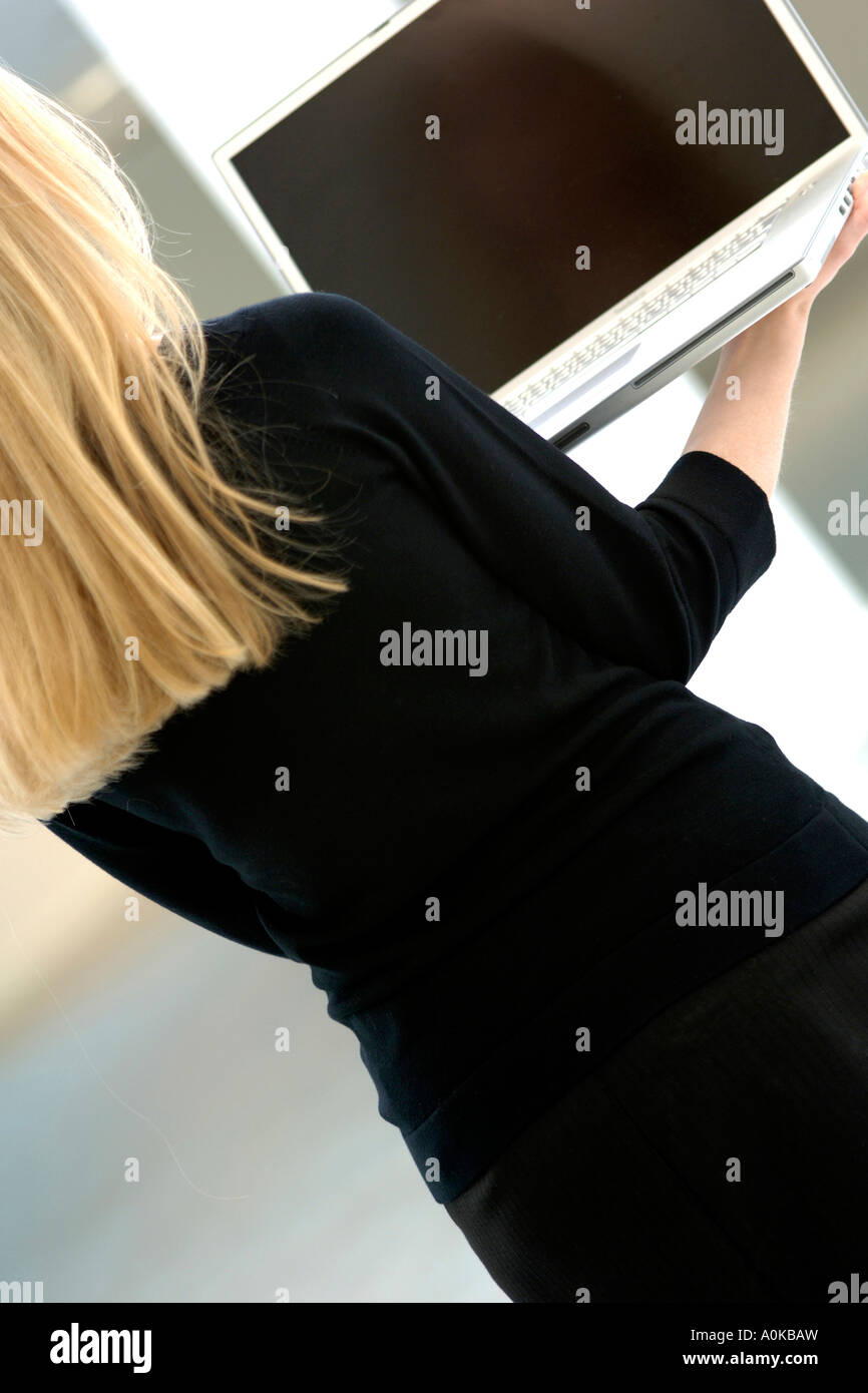 rear view of woman carrying notebook computer Stock Photo - Alamy