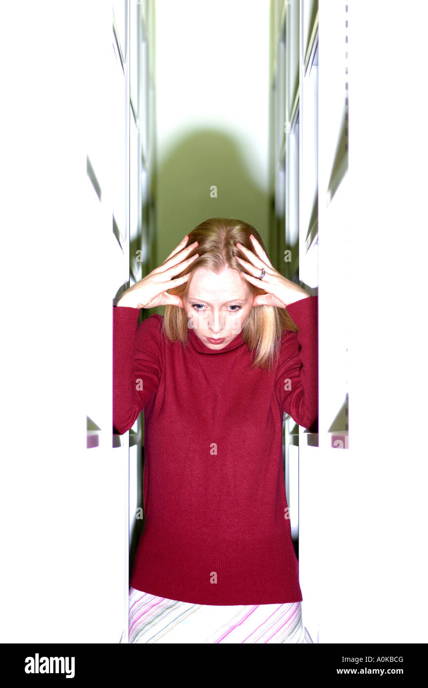 stressed young woman standing between shelves Stock Photo - Alamy