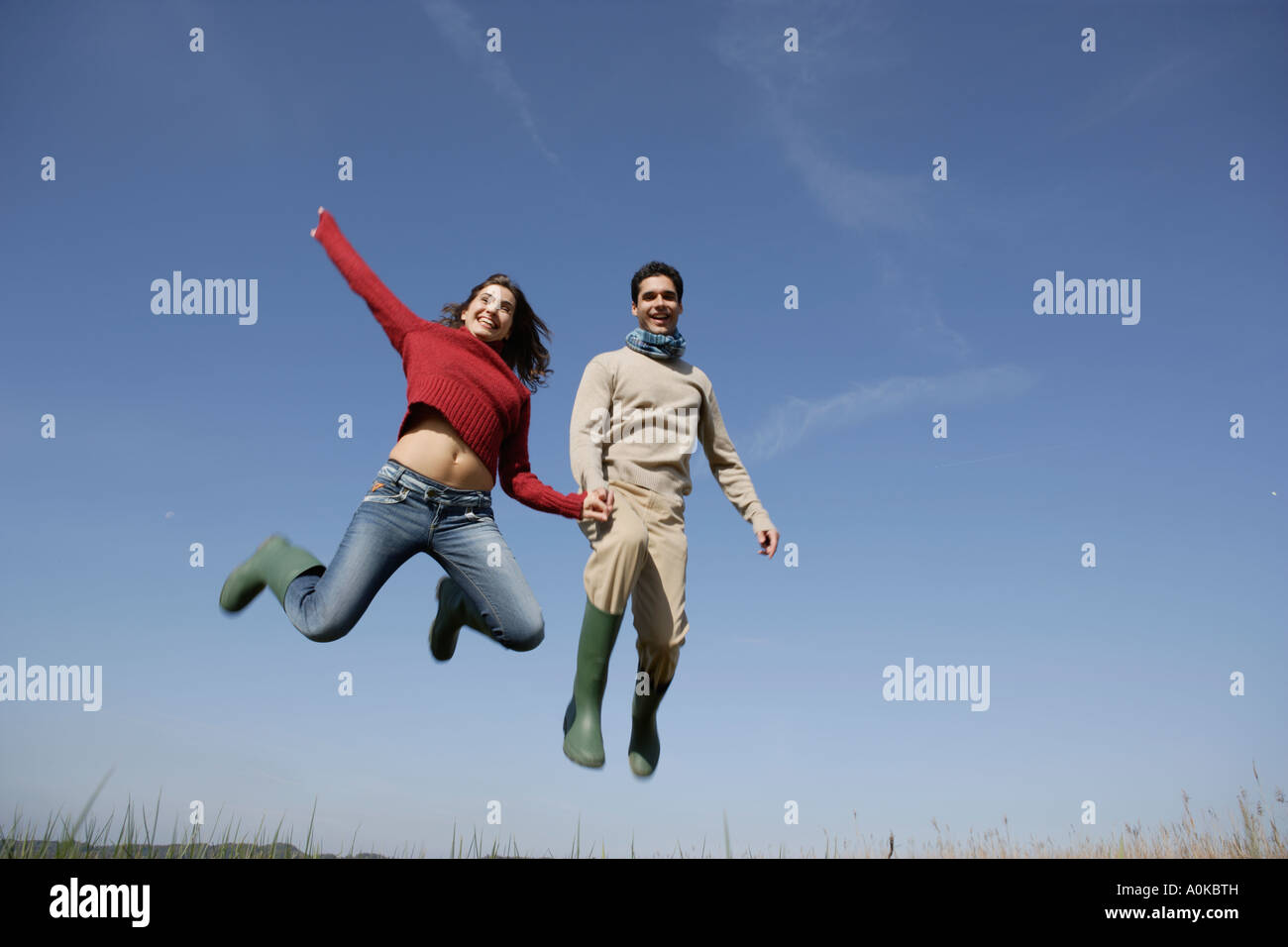 couple holding hands and jumping for joy Stock Photo - Alamy