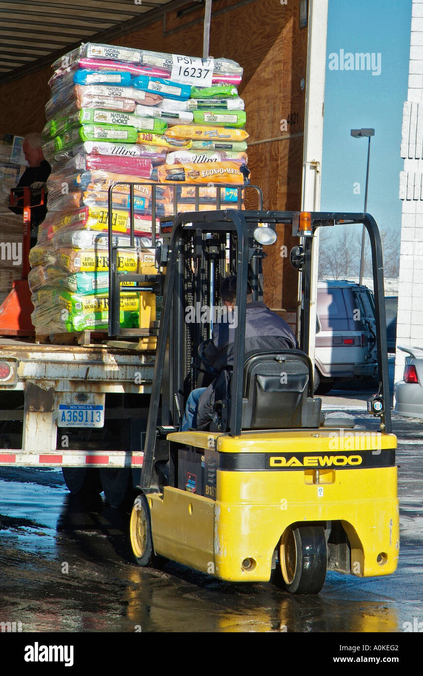 Fork lift operator moves a load of heavy products from a truck to a ...