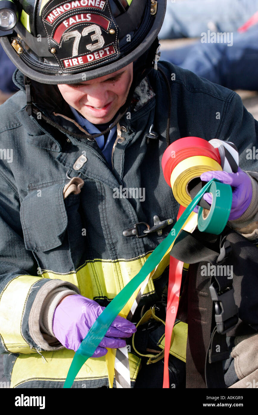 An EMT at a scene of a mass casualty exercise is using colored ribbons ...