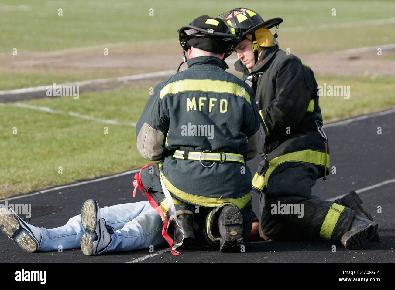 Two EMTs at a mass casualty exercise using colored ribbons to assign ...