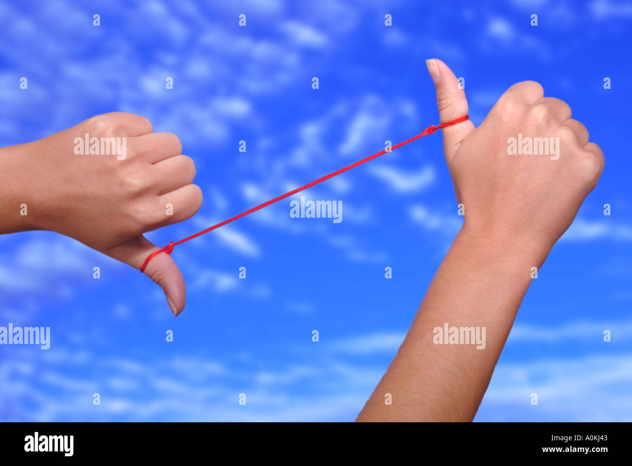 Two thumbs connected via string Stock Photo - Alamy