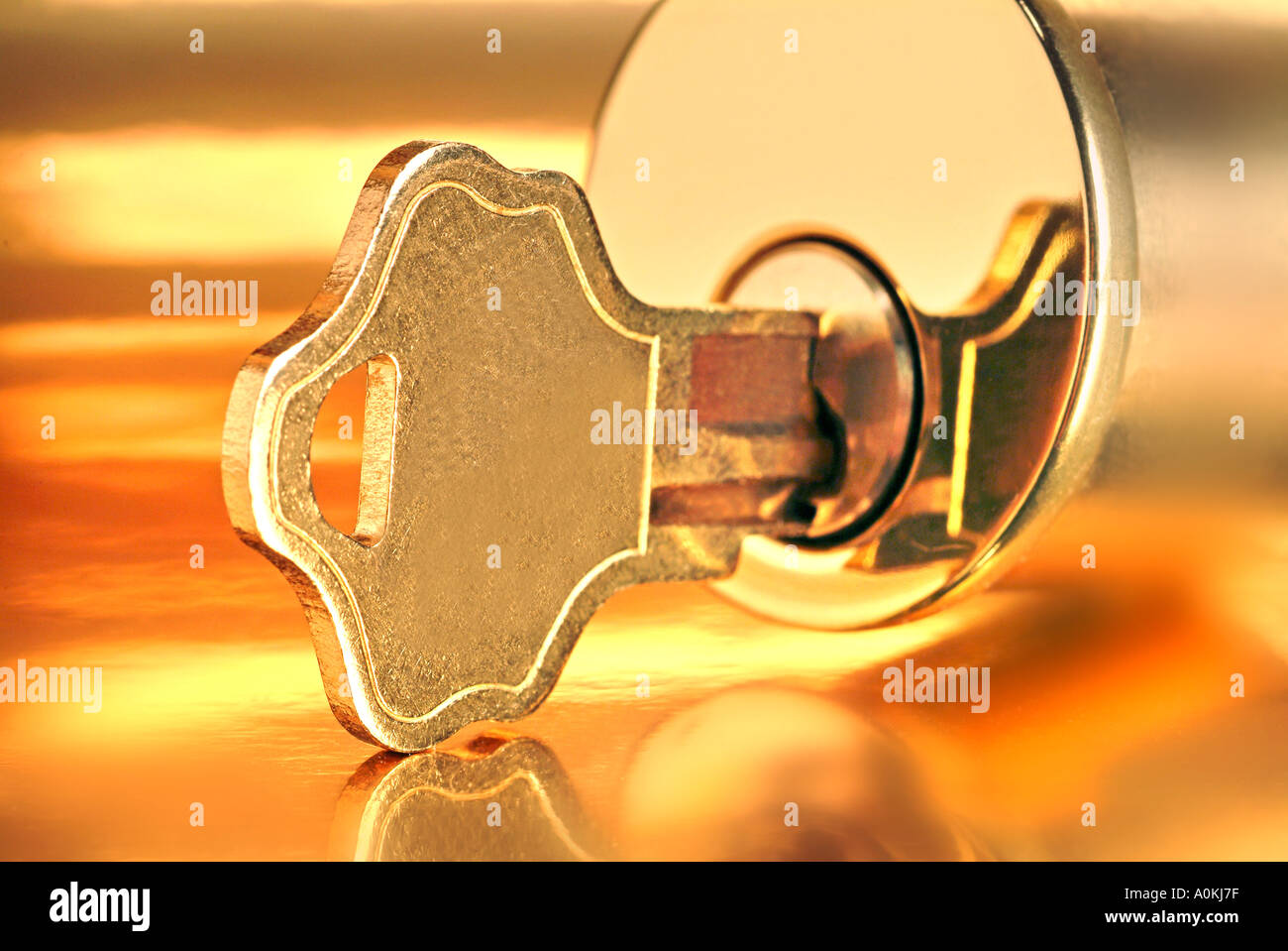 Brass security key and deadbolt on gold background Stock Photo - Alamy