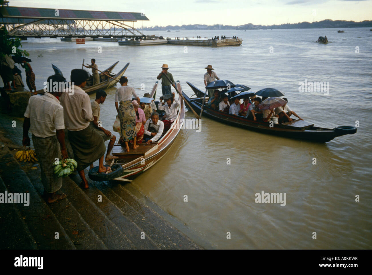 Passengers get on to ferry boats to cross the Yangon River in Yangon ...