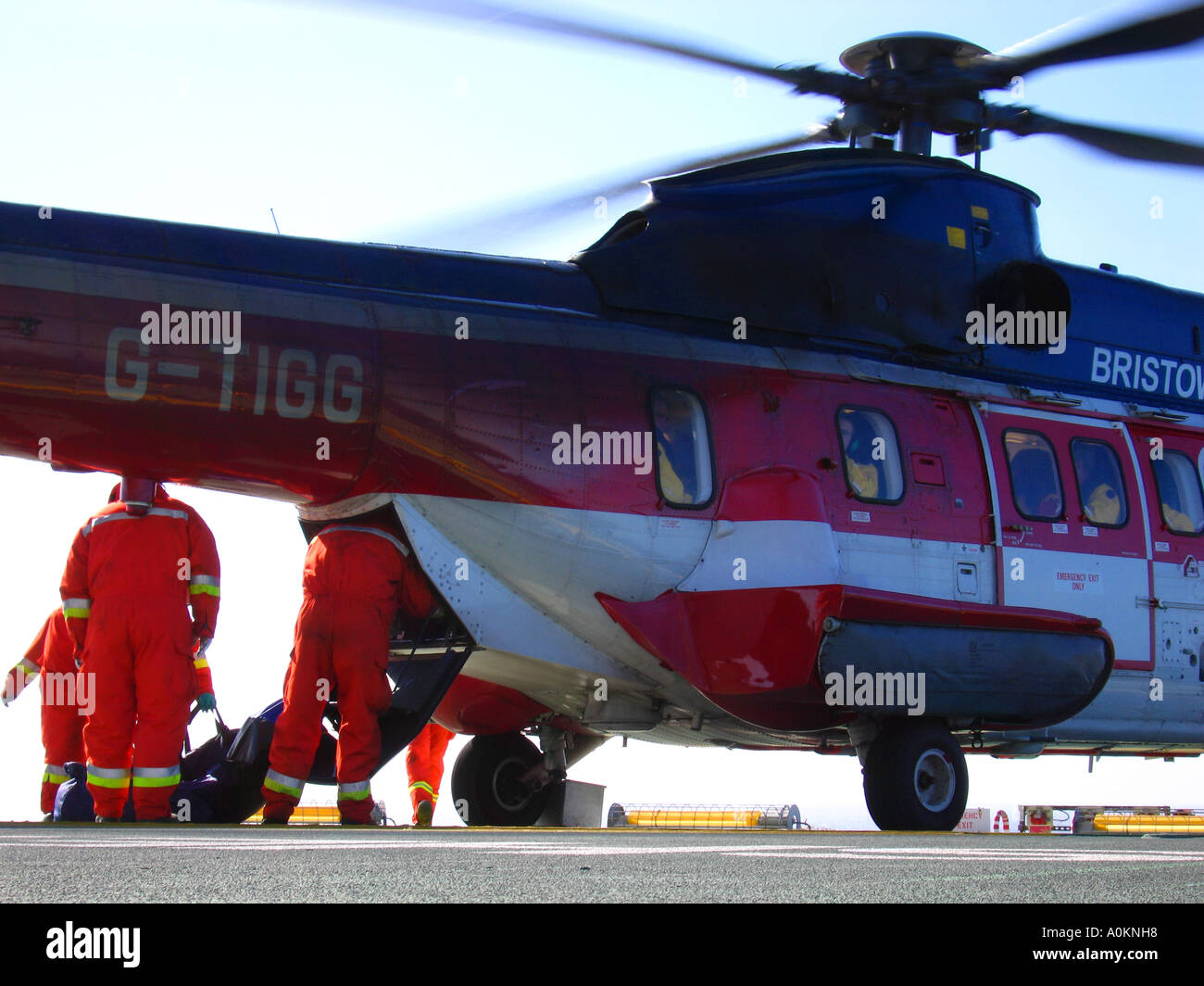A North sea helicopter on deck on an oil rig with helideck crew ...