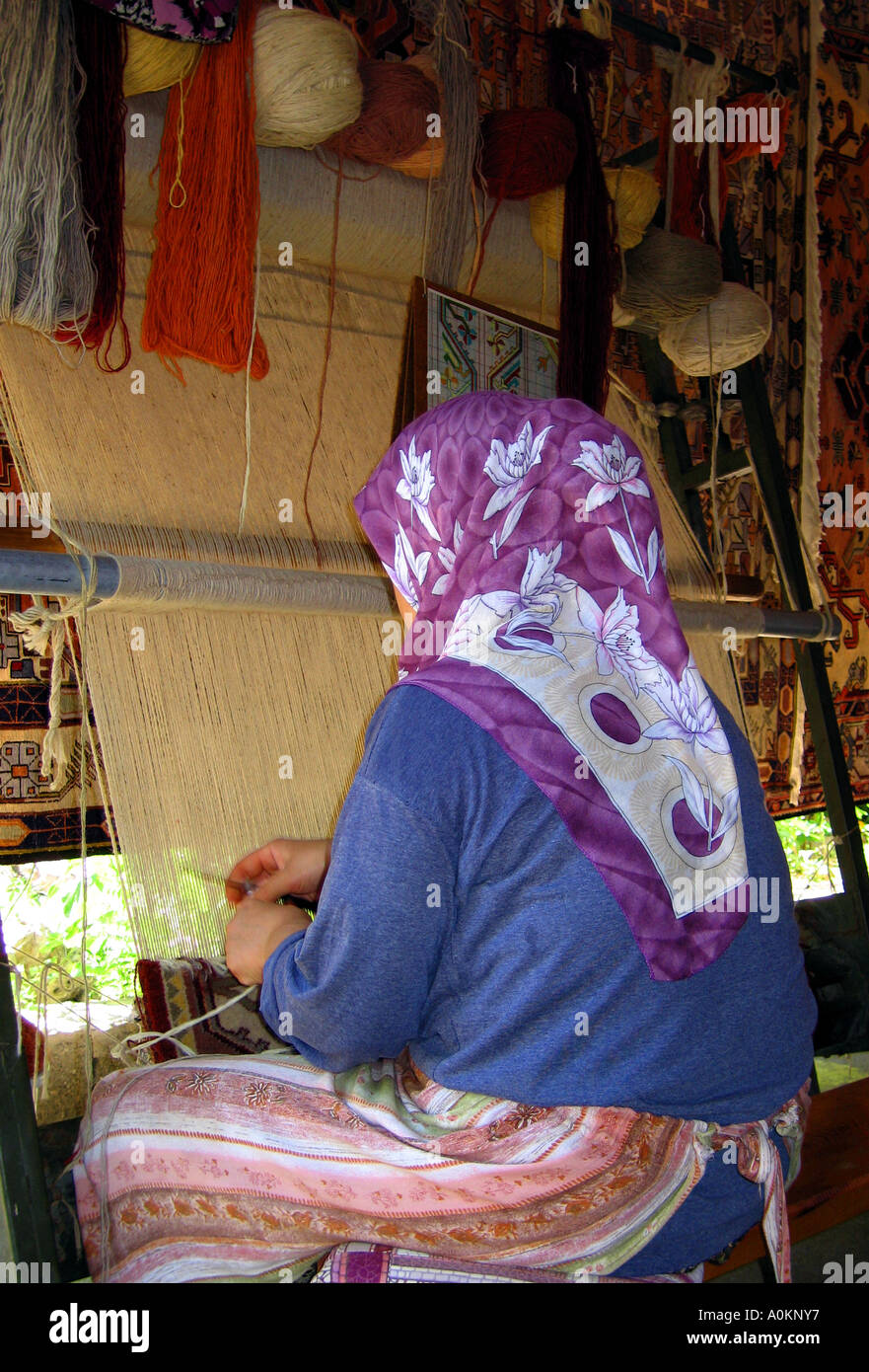 A female turkish carpet maker sitting down weaving Stock Photo - Alamy