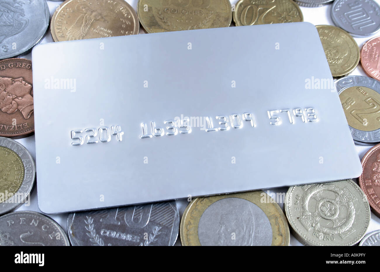 Credit card over coins Stock Photo - Alamy