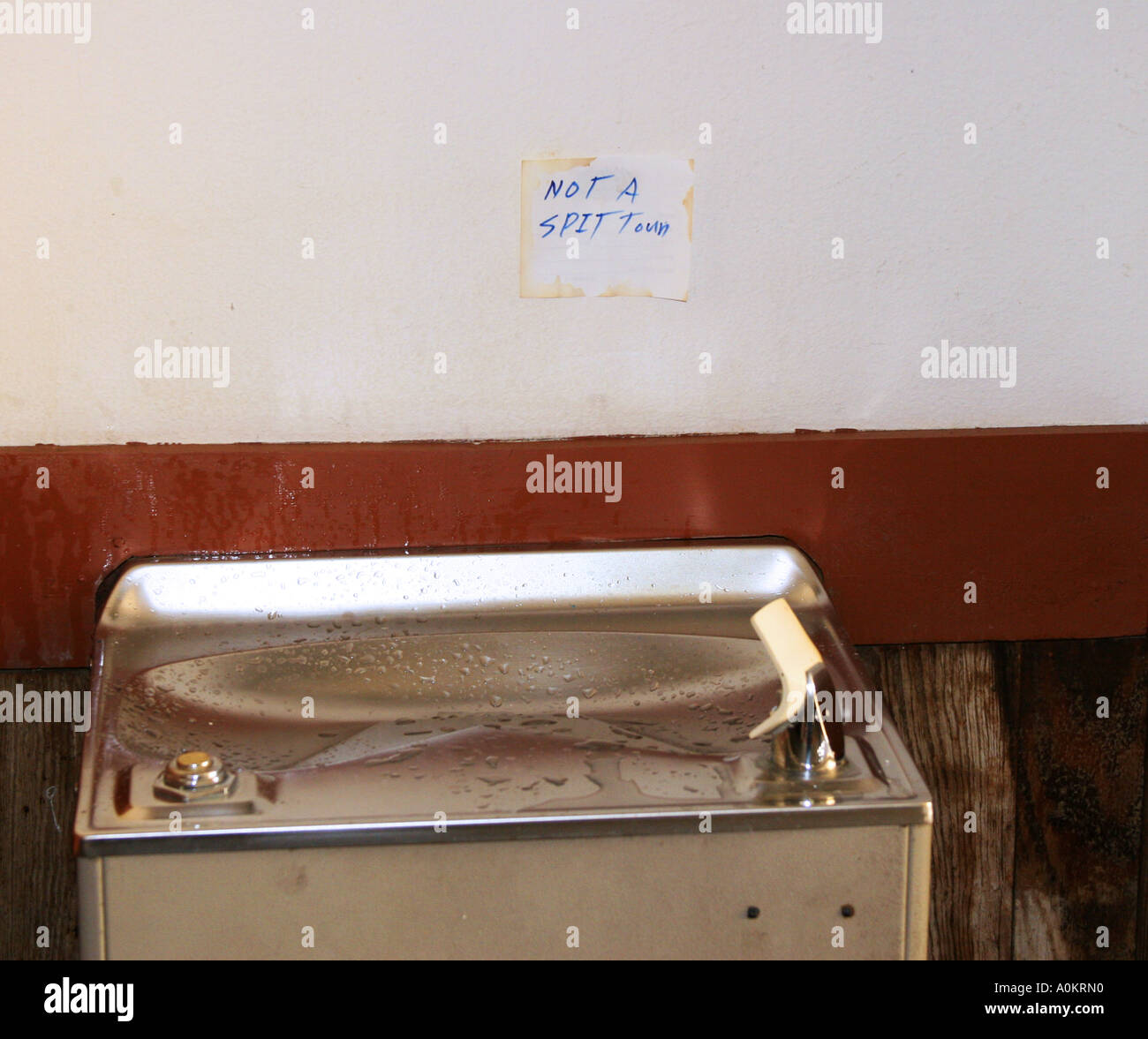 Water fountain with a sign that reads Not a spittoon Stock Photo - Alamy