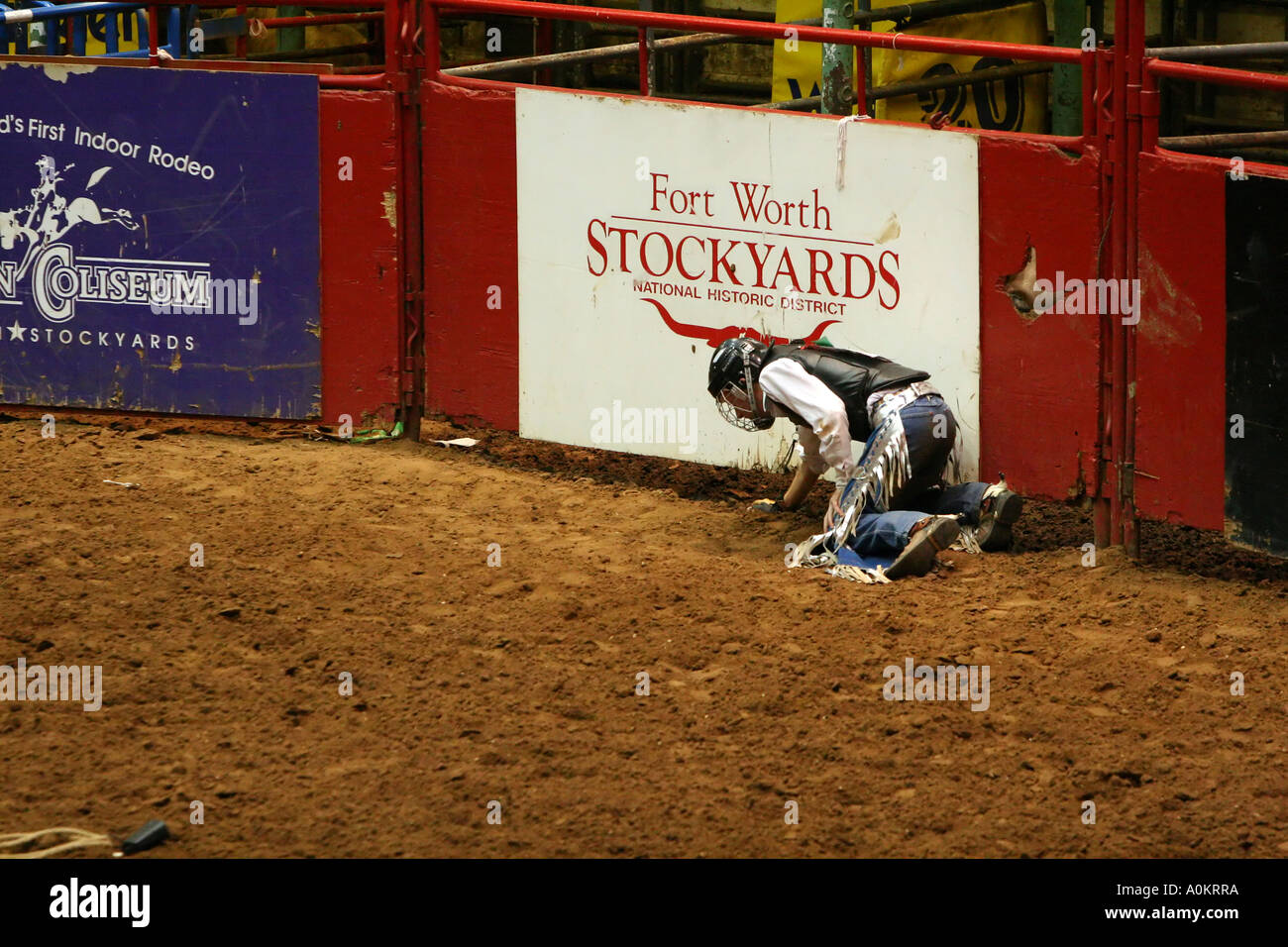 An injured bull rider kneels and holds his leg Stock Photo - Alamy