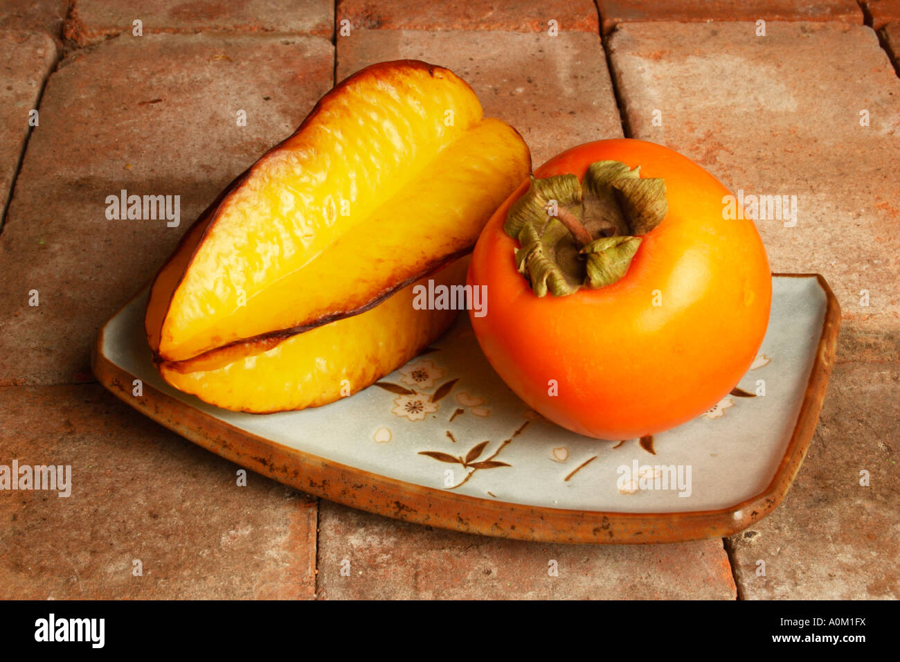 Star fruit and Giant Sharon fruit on an Oriental plate Stock Photo - Alamy