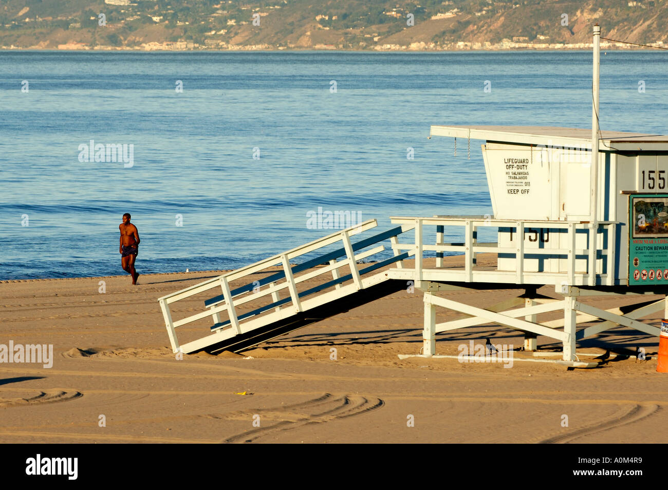 African-American male running by lifeguard tower in Santa Monica ...