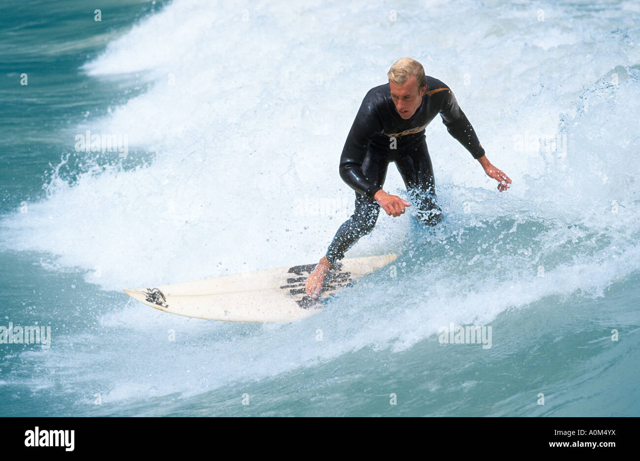 young man surfing on river Isar in the middle of Munich Bavaria Germany ...