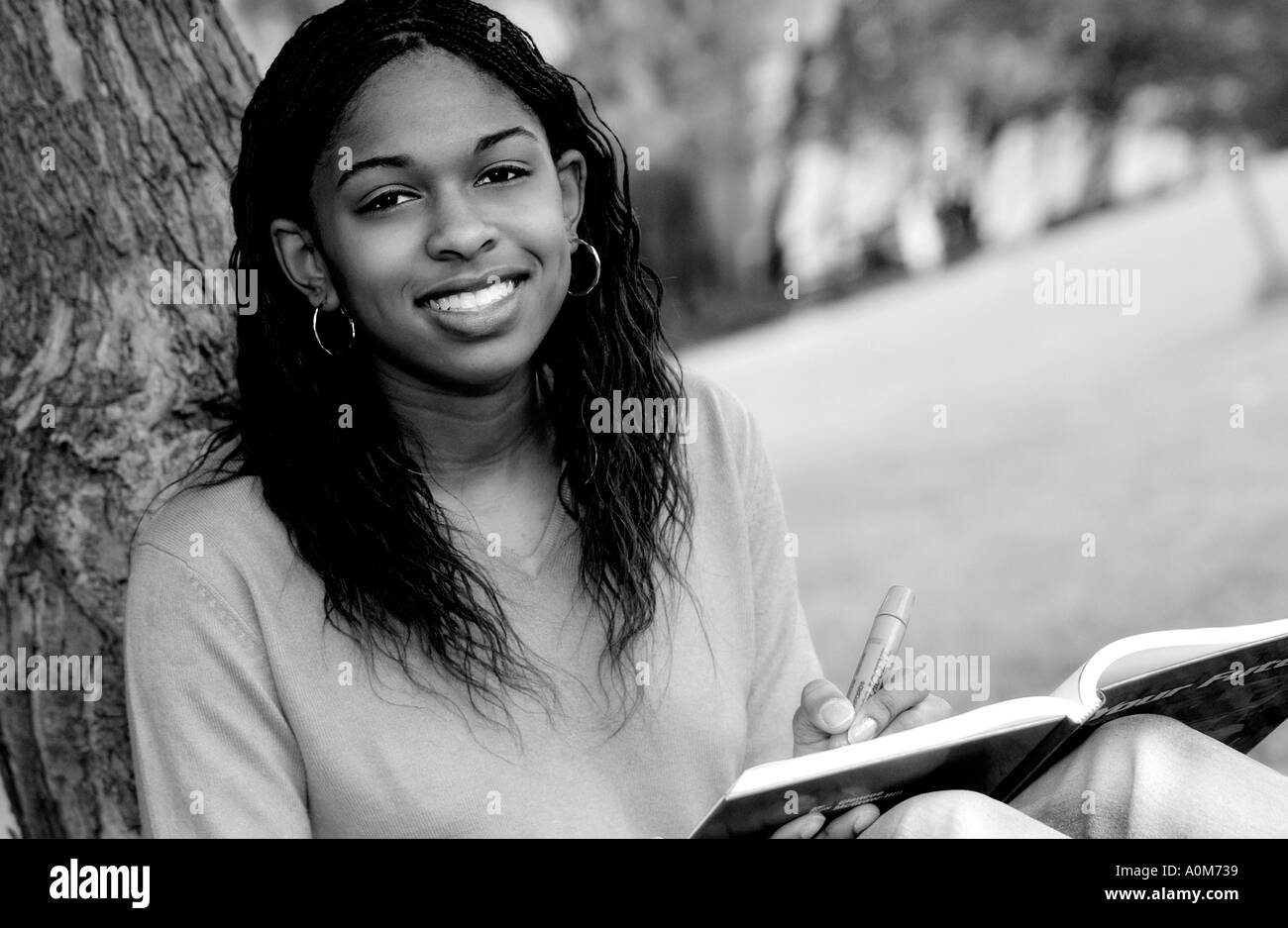 Woman sitting under tree reading Black and White Stock Photos & Images ...