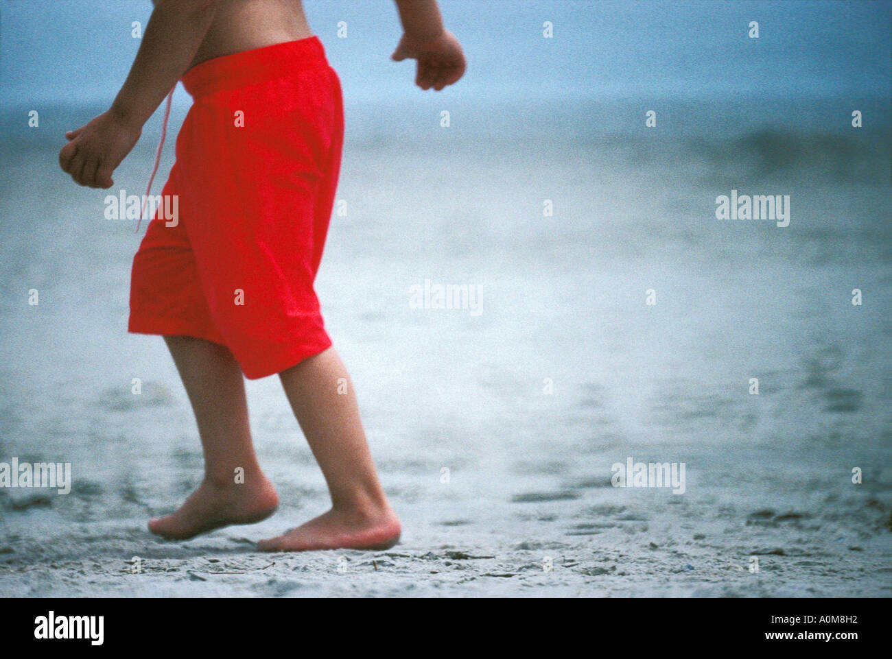 1 one young boy bright red swim trunks on beach Stock Photo - Alamy