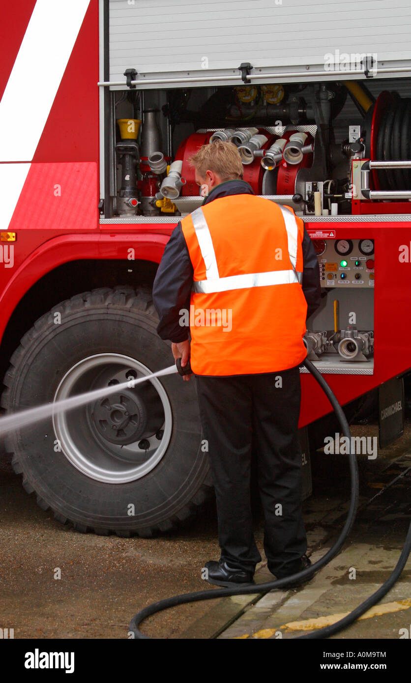 Fireman cleaning fire engine with jet pressure washer. UK Stock Photo ...